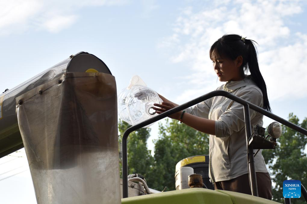 Pic story: female operator aids villagers with combine harvester ...